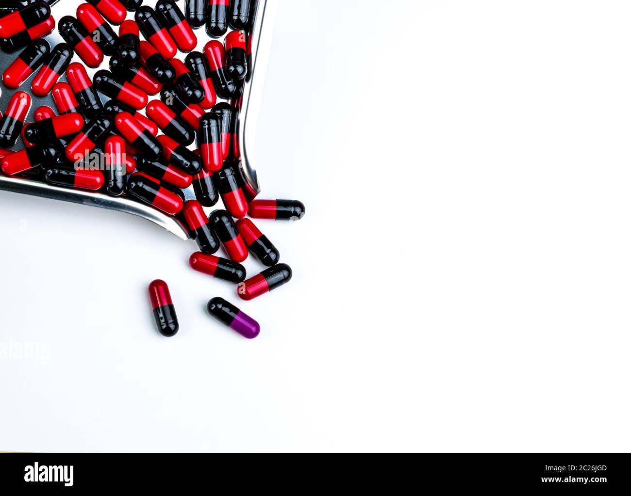 Red-black capsule pills on drug tray. Antibiotics drug resistance ...
