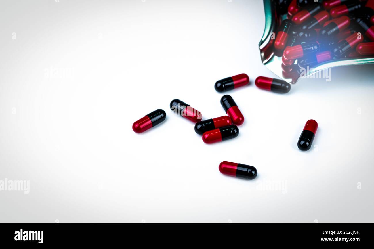 Red-black capsule pill on drug tray. Medicine for treatment and ...