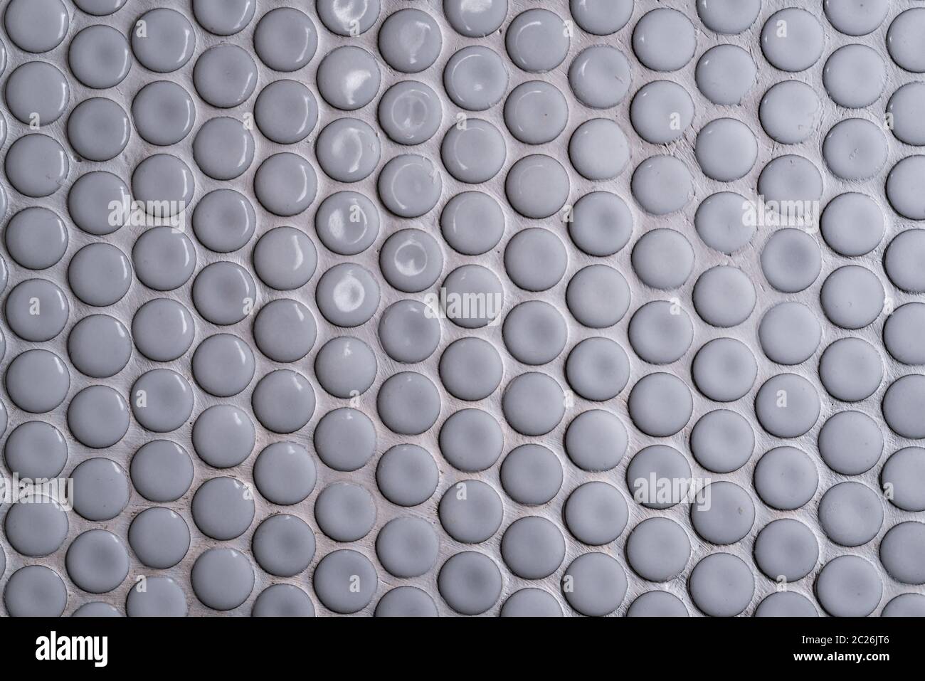 White ceramic tile wall with many small round unique pattern. Top view ...