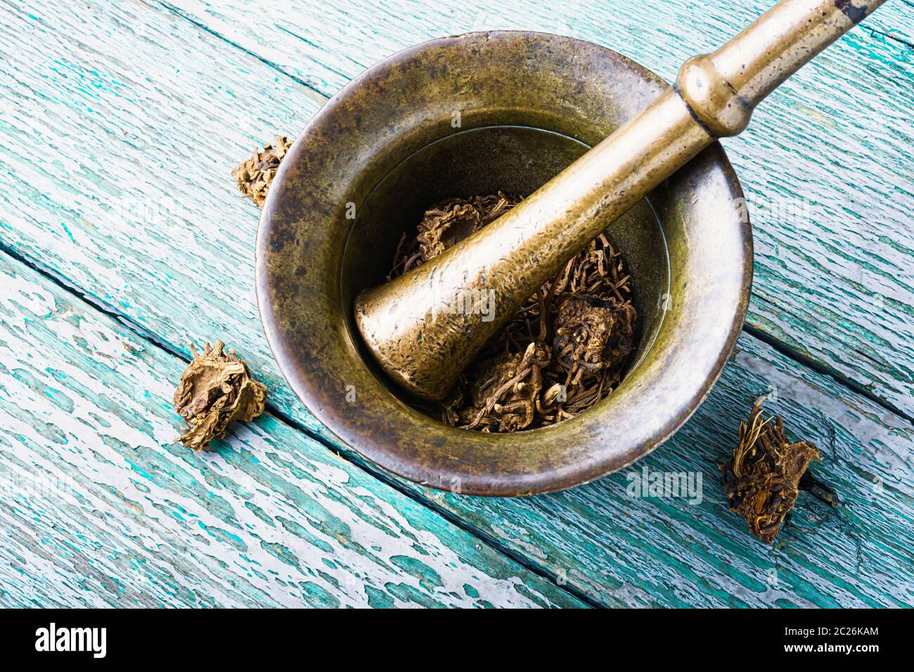 Dried Valerian roots in old bronze mortar.Valerian root for medical use ...