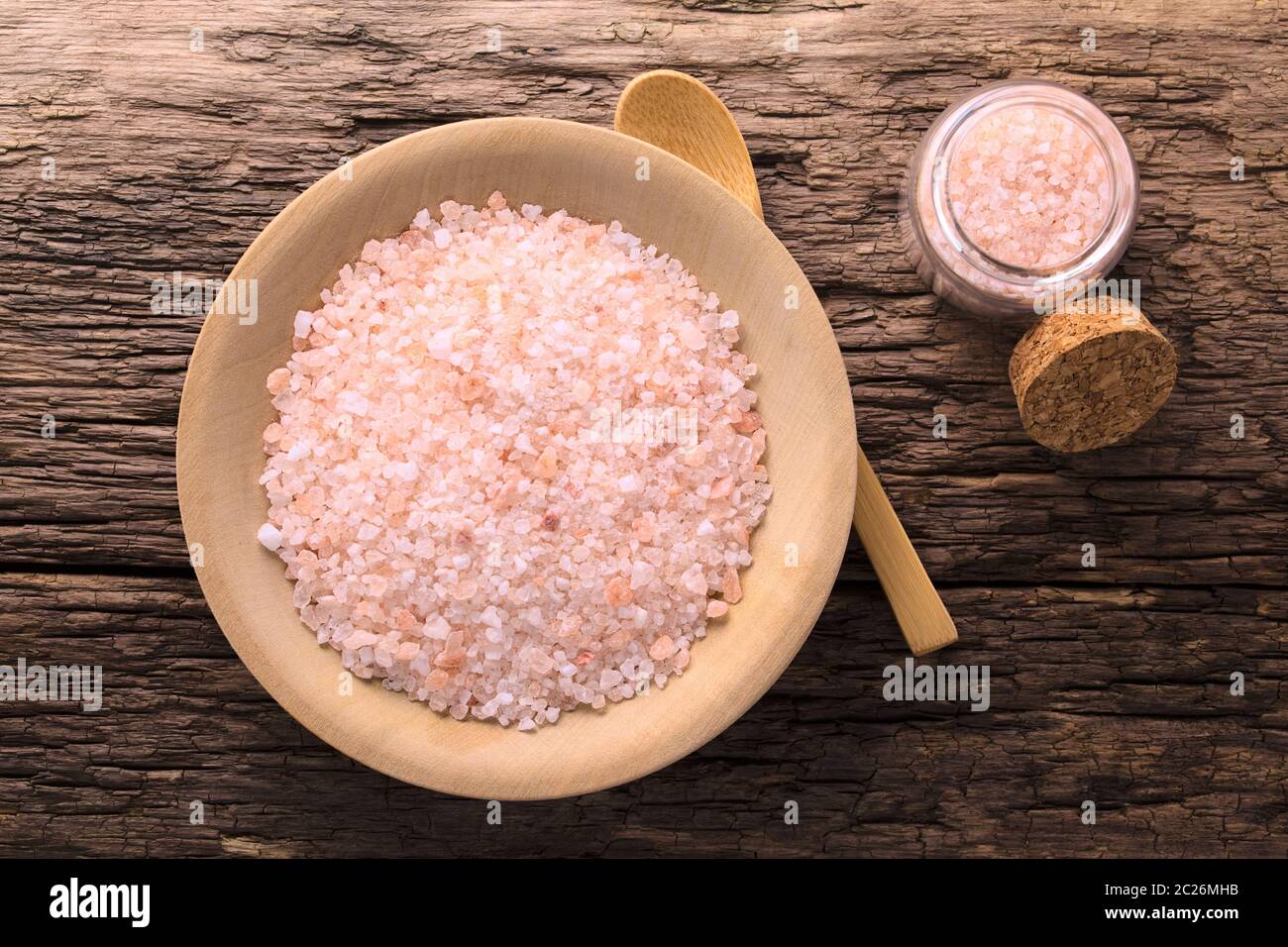 Coarse pink Himalayan salt on wooden plate, wooden spoon and small ...