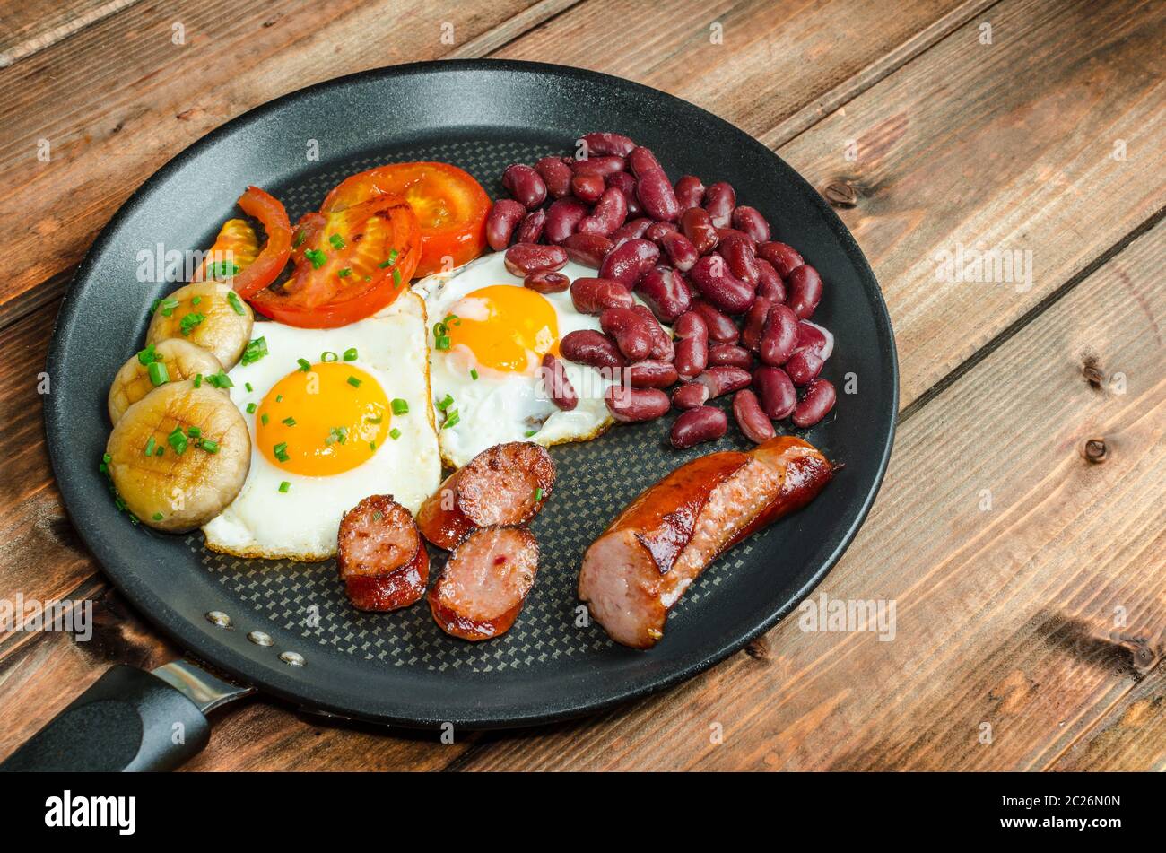 English breakfast on frying pan and wood table Stock Photo - Alamy