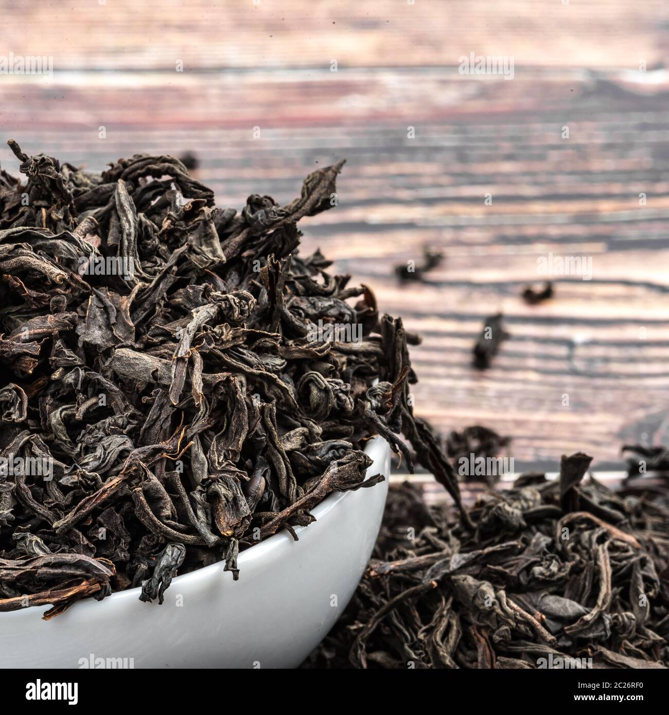Dried tea is poured into a ceramic cup on a wooden plank table Stock ...