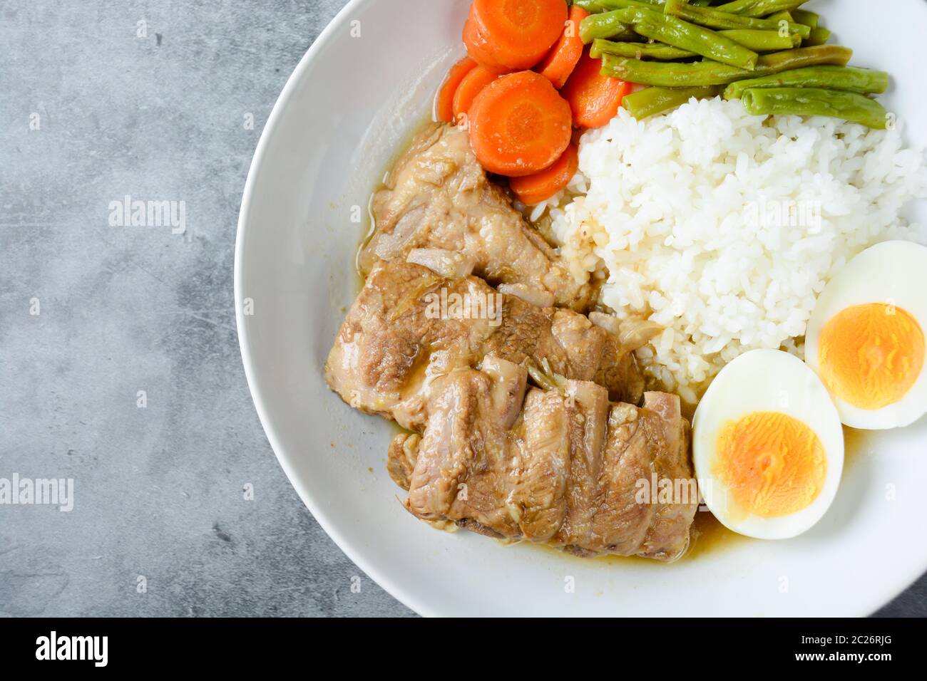 Baked pork ribs with rice, boiled egg and vegetable Stock Photo - Alamy