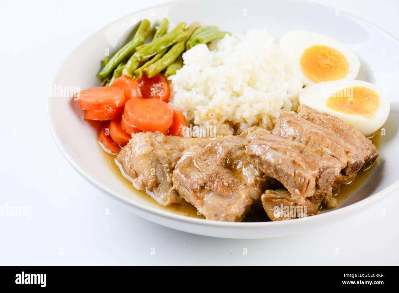 Baked pork ribs with rice, boiled egg and vegetable Stock Photo - Alamy