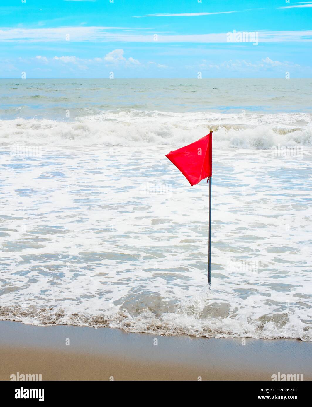 Waving red flag at seashore Stock Photo - Alamy