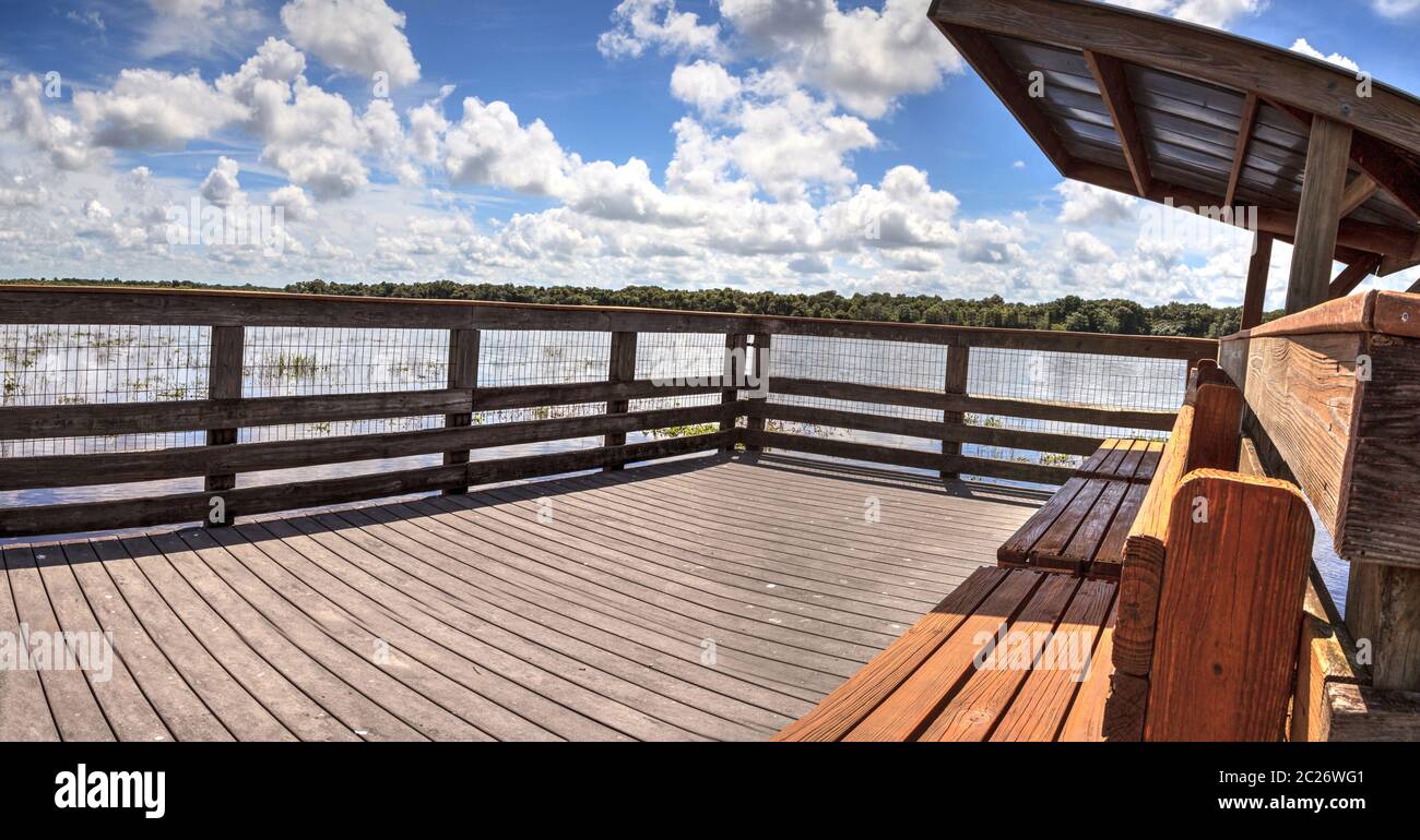 Boardwalk with benches overlooking the flooded swamp of Myakka River ...
