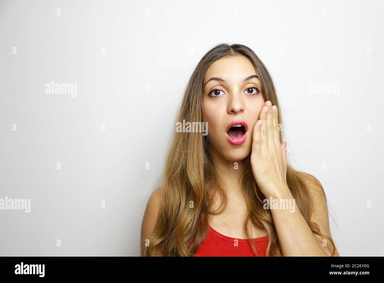 Surprised woman with red lips holds cheeks by hand. Beautiful girl with ...