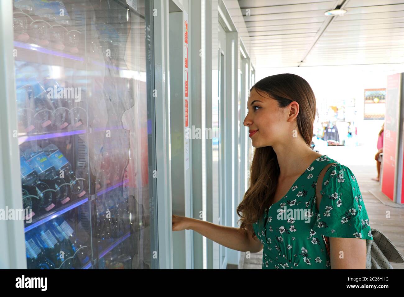 Young female backpacker tourist choosing a snack or drink at vending ...