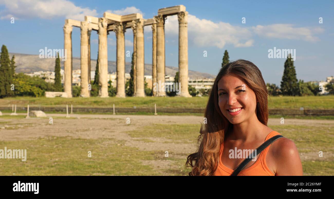 Smiling tourist woman with the greek temple of Olympian Zeus on the ...