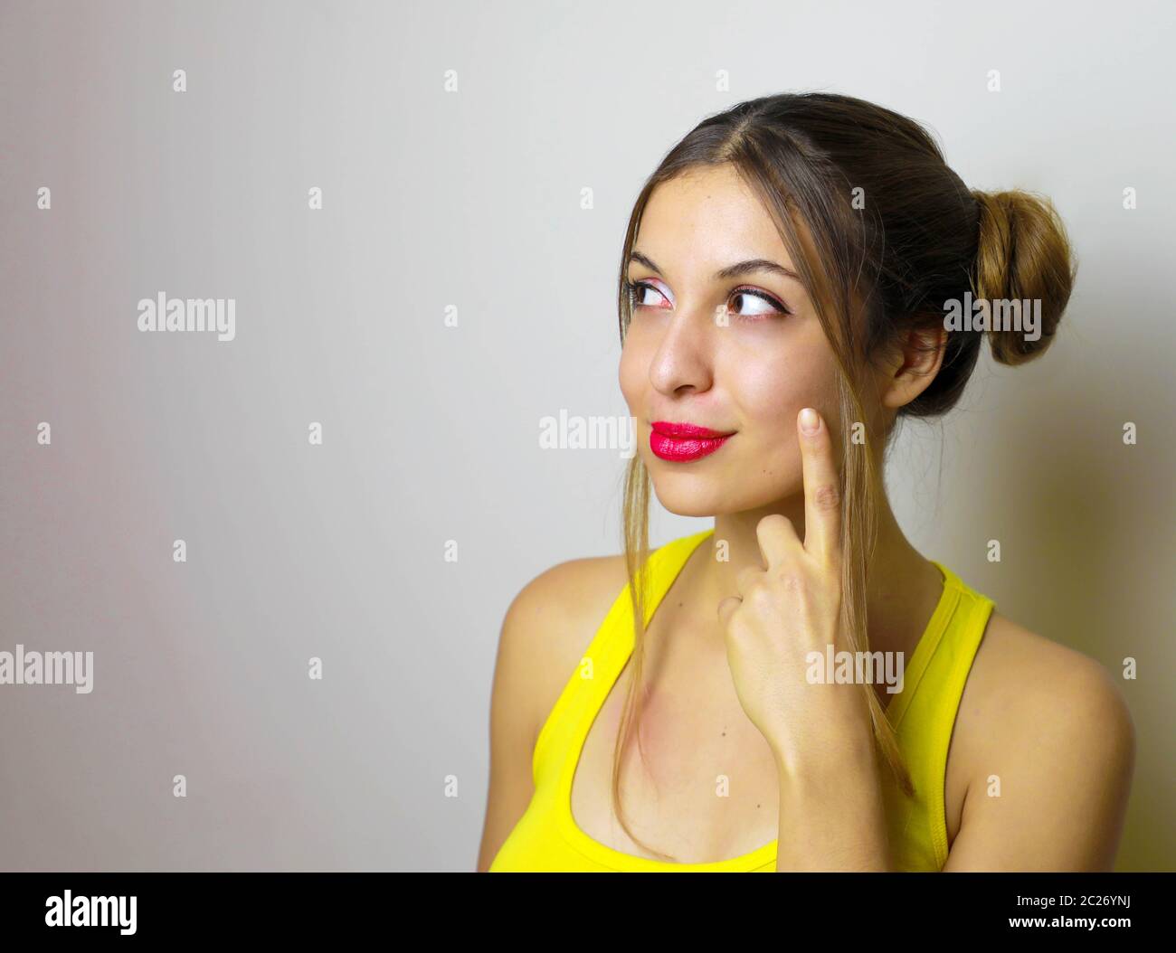 Single young attractive thinking woman with finger on cheeck and ...