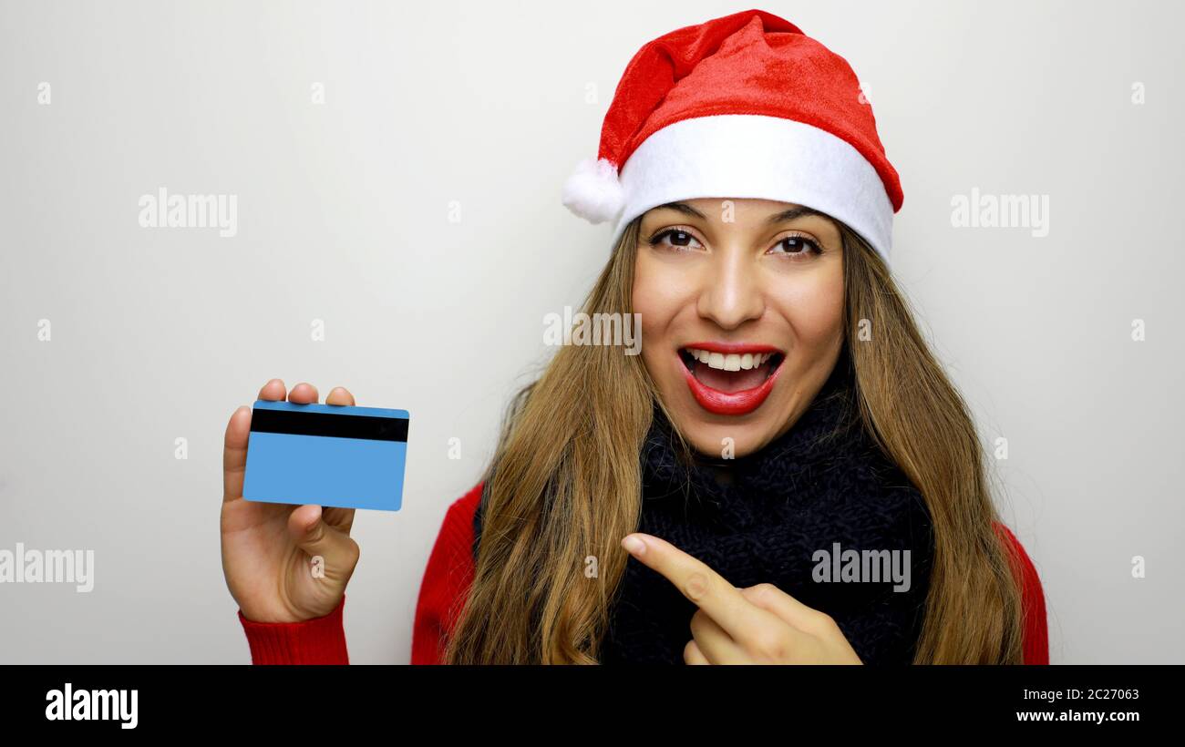 Christmas woman holding credit card pointing finger on white background ...