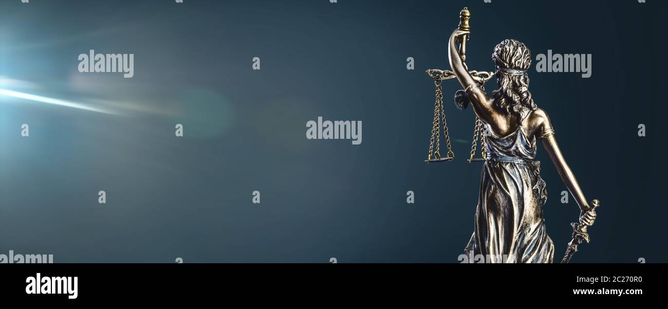 Statue of lady justice on dark background - rear view with copy space ...