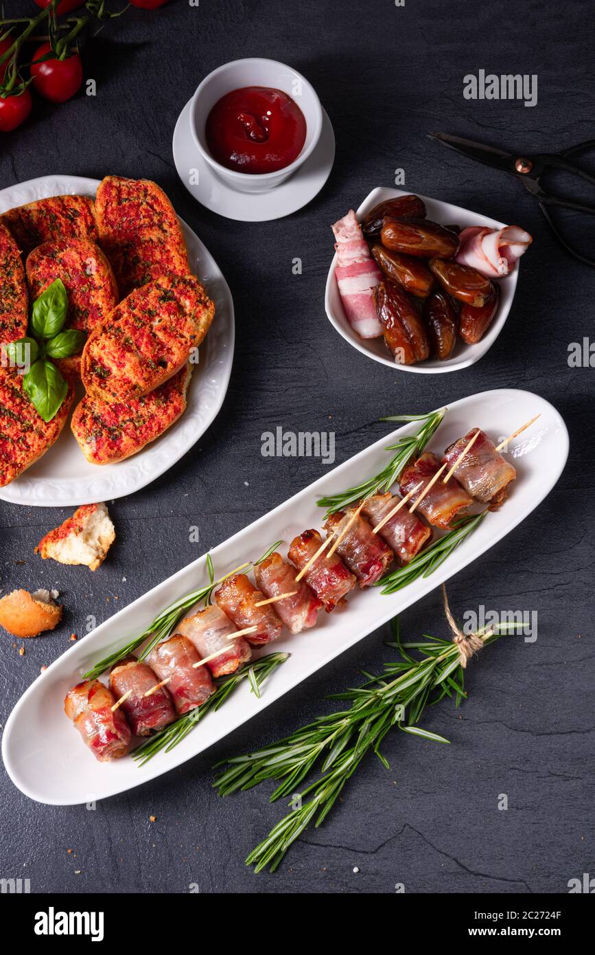 dates wrapped in bacon and delicious tapas Stock Photo - Alamy