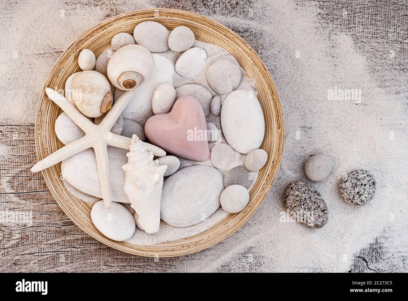 maritime still life with heart in a bamboo bowl on wooden background ...