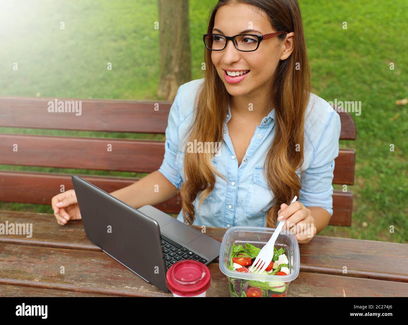 Business woman eating salad on lunch break in city park living healthy ...