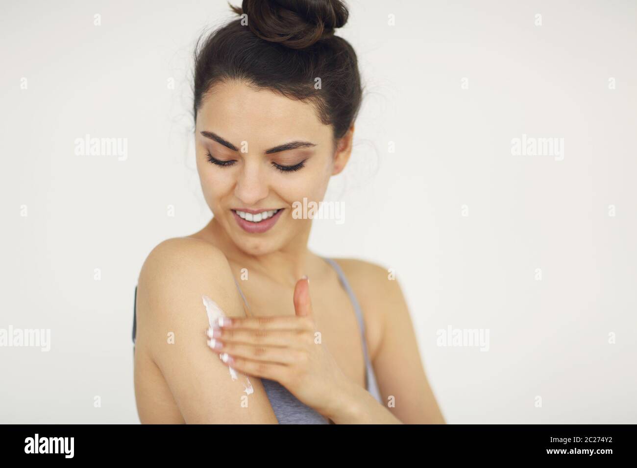 Young woman applying body cream on perfect skin Stock Photo - Alamy