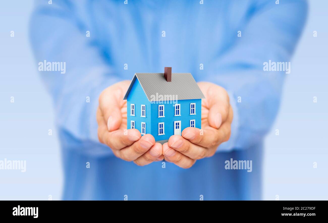 Small blue toy house in hands Stock Photo - Alamy