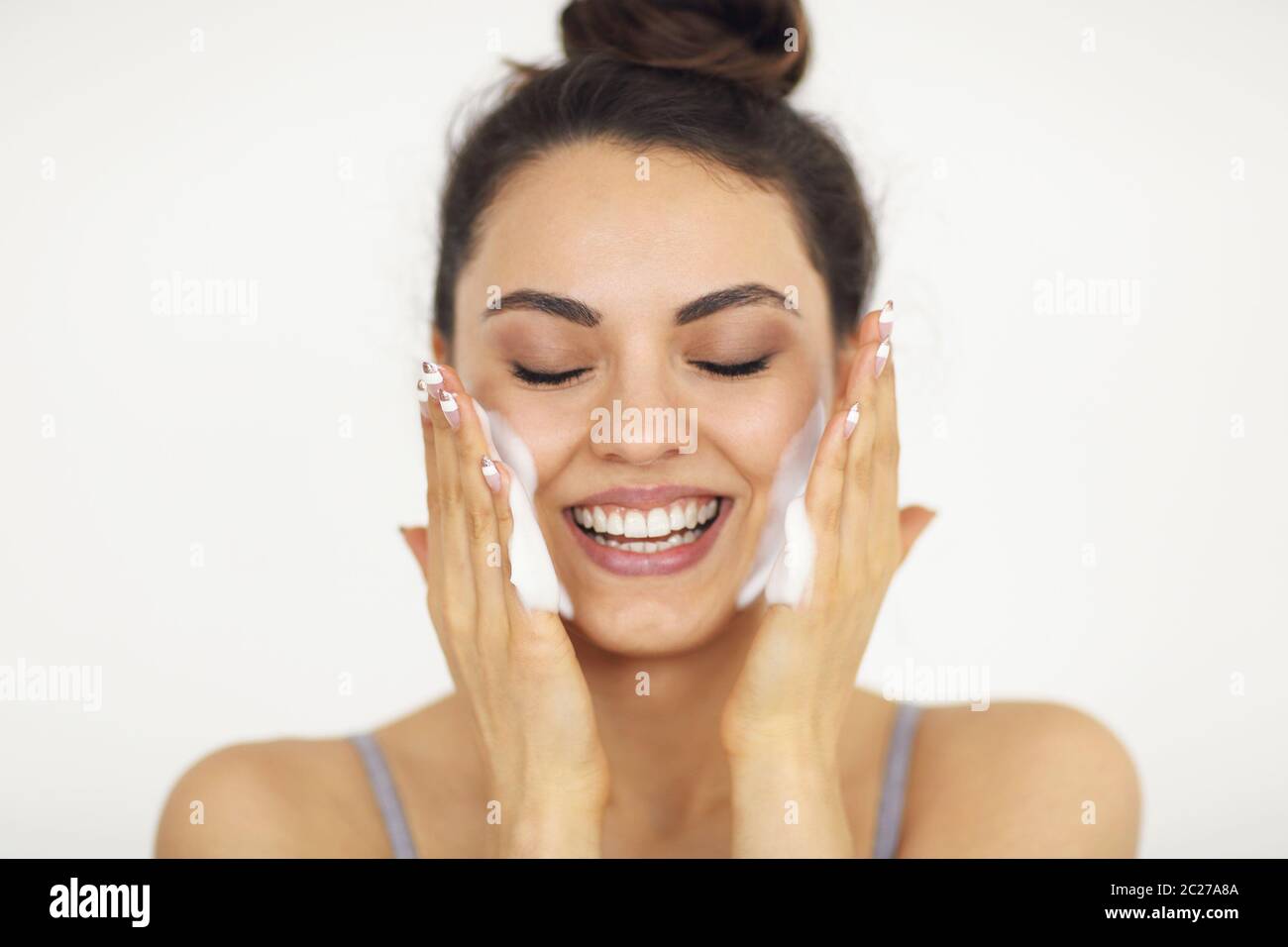 Beautiful young caucasian woman washing her face with foam Stock Photo ...