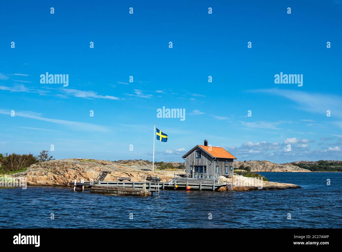 Cottage and flag on the island Valoen near the city Fjaellbacka in ...
