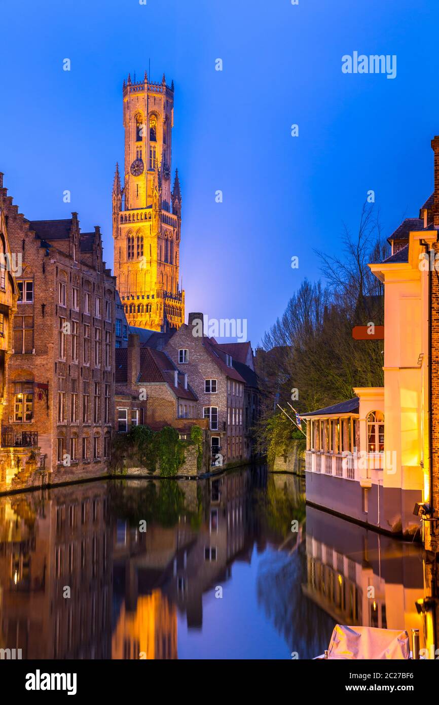 Historic medieval buildings along a canal in Bruges, Belgium at dusk ...