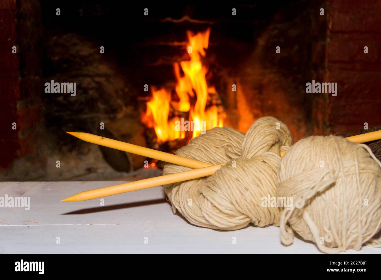 winter concept knitting wool and tricot needles with fire from home on ...