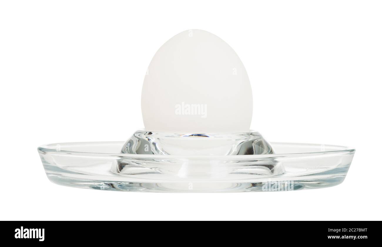 side view of boiled white egg in glass egg cup isolated on white ...
