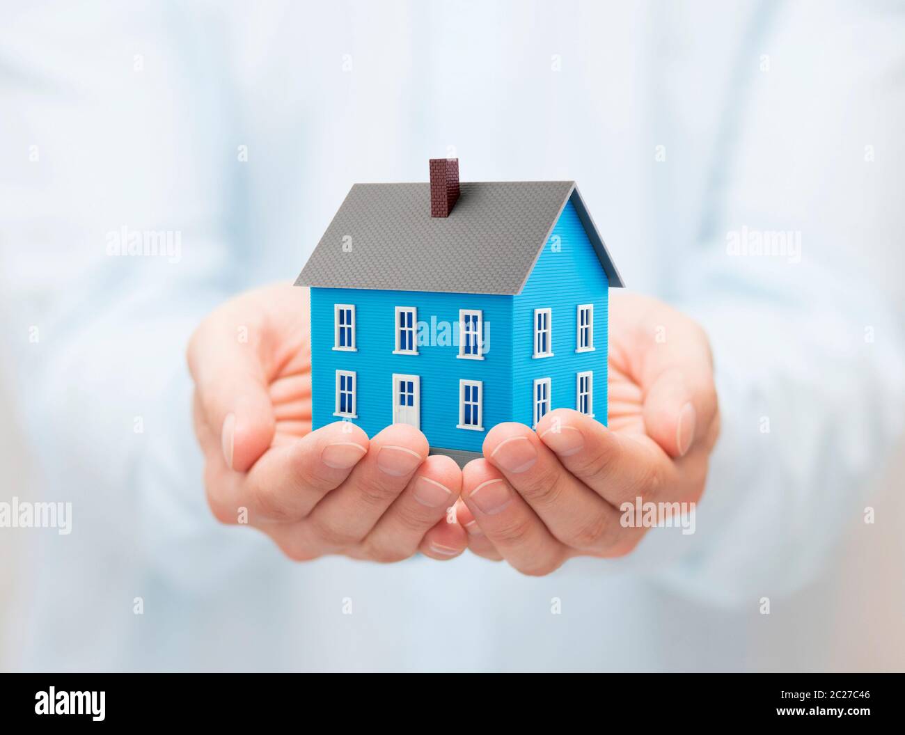 Small blue toy house in hands Stock Photo - Alamy