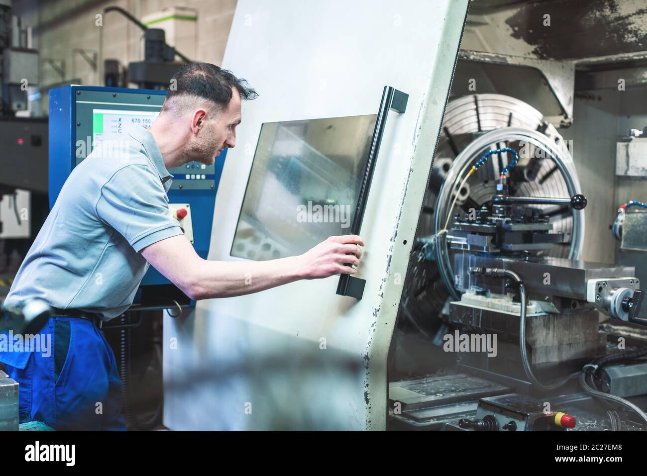 Worker man operating a CNC lathe in factory Stock Photo - Alamy