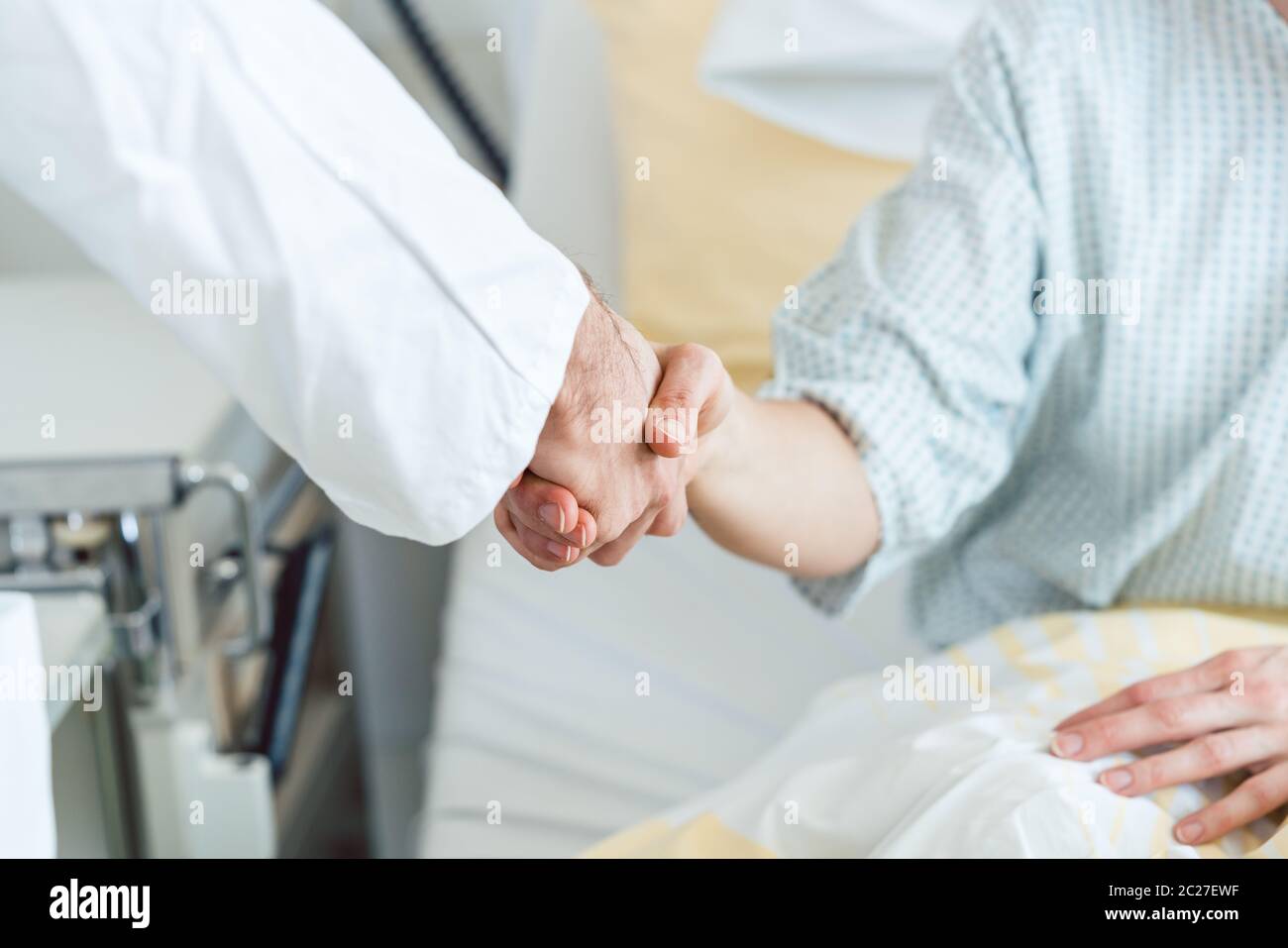 Doctor shaking hand of patient in hospital bed, closeup Stock Photo - Alamy