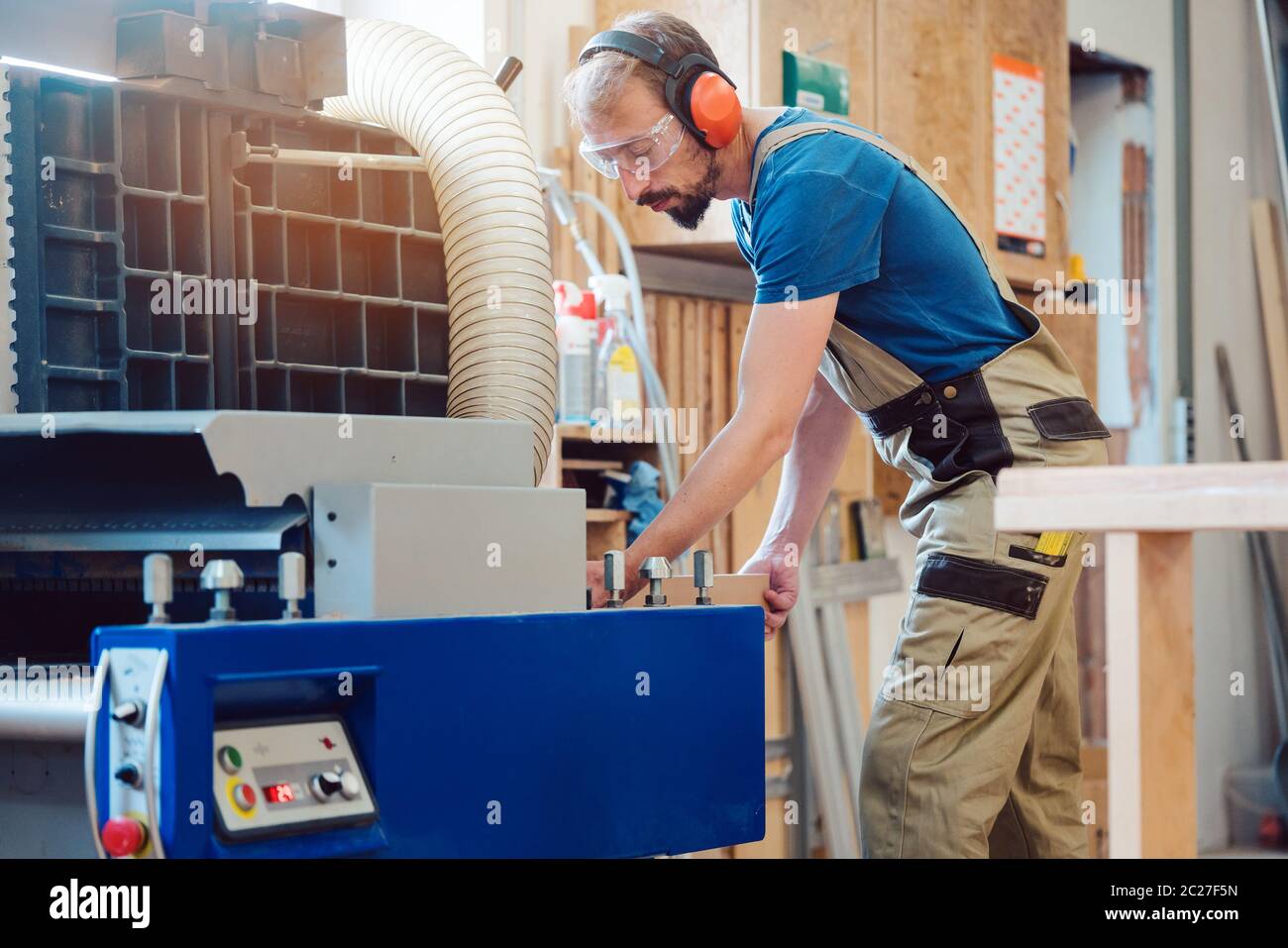 Carpenter working with wood at the circular cutter Stock Photo - Alamy