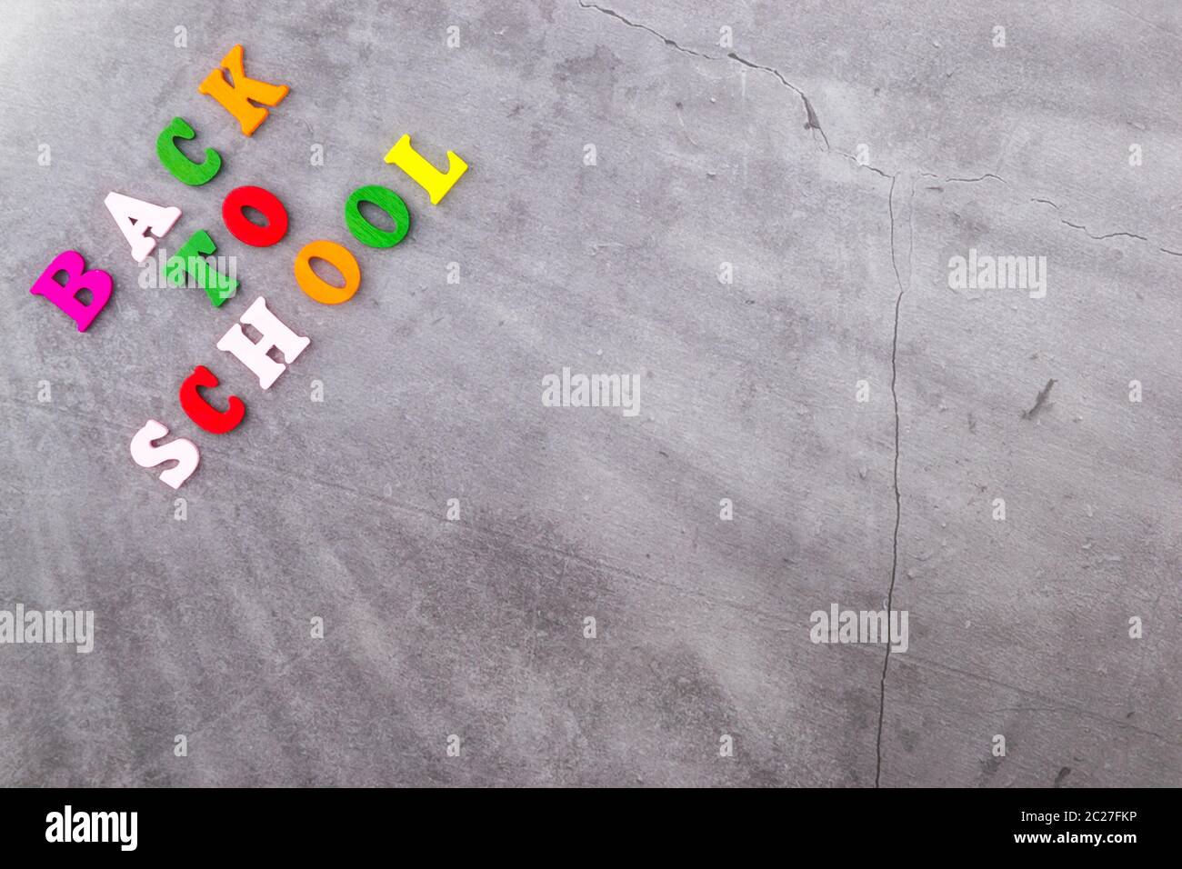 The layout of school supplies on a dark gray background. Top view, the ...