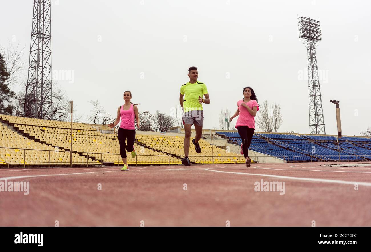 Three athlete people running in speed on sport ground Stock Photo - Alamy