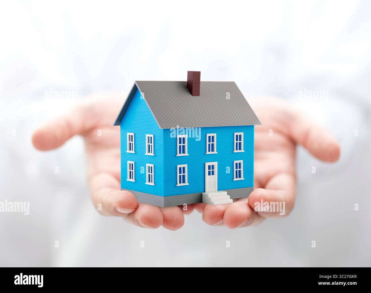 Small blue toy house in hands Stock Photo - Alamy