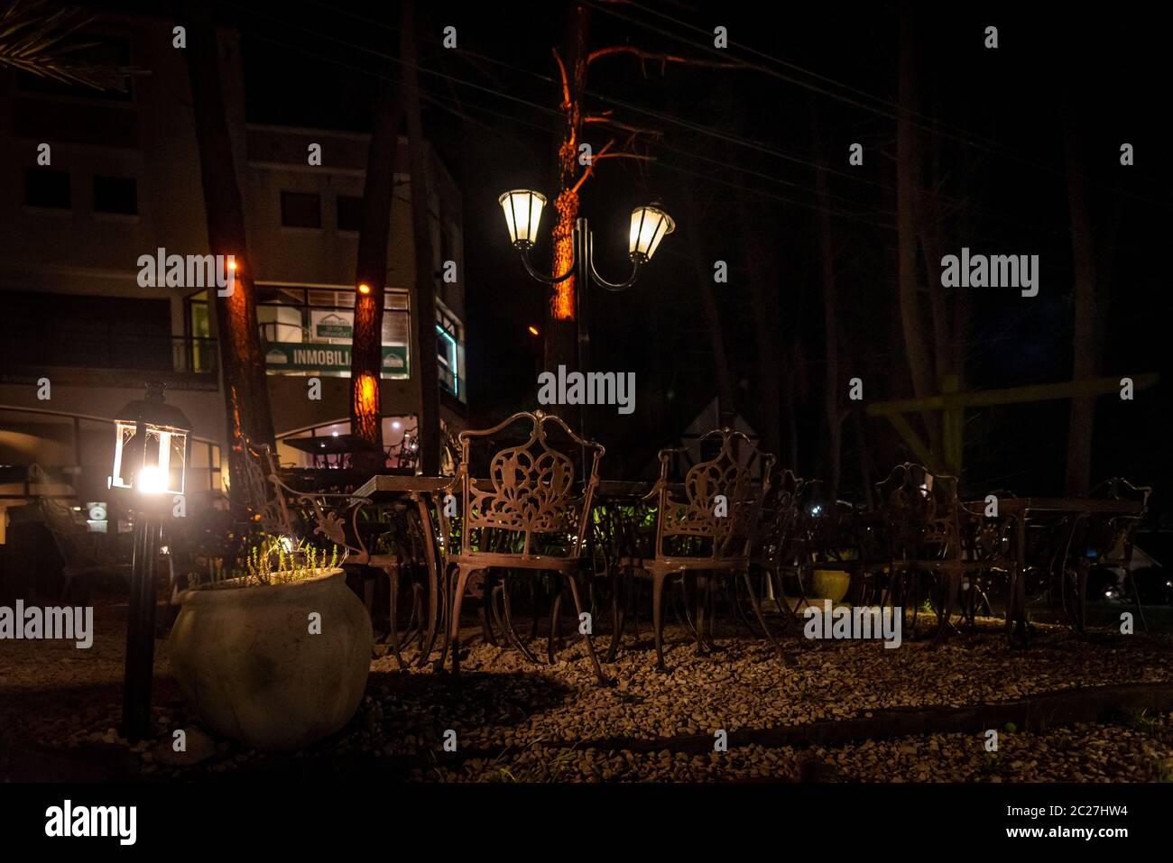 Night scene of an elegant outdoor bar illuminated by small lamps among ...