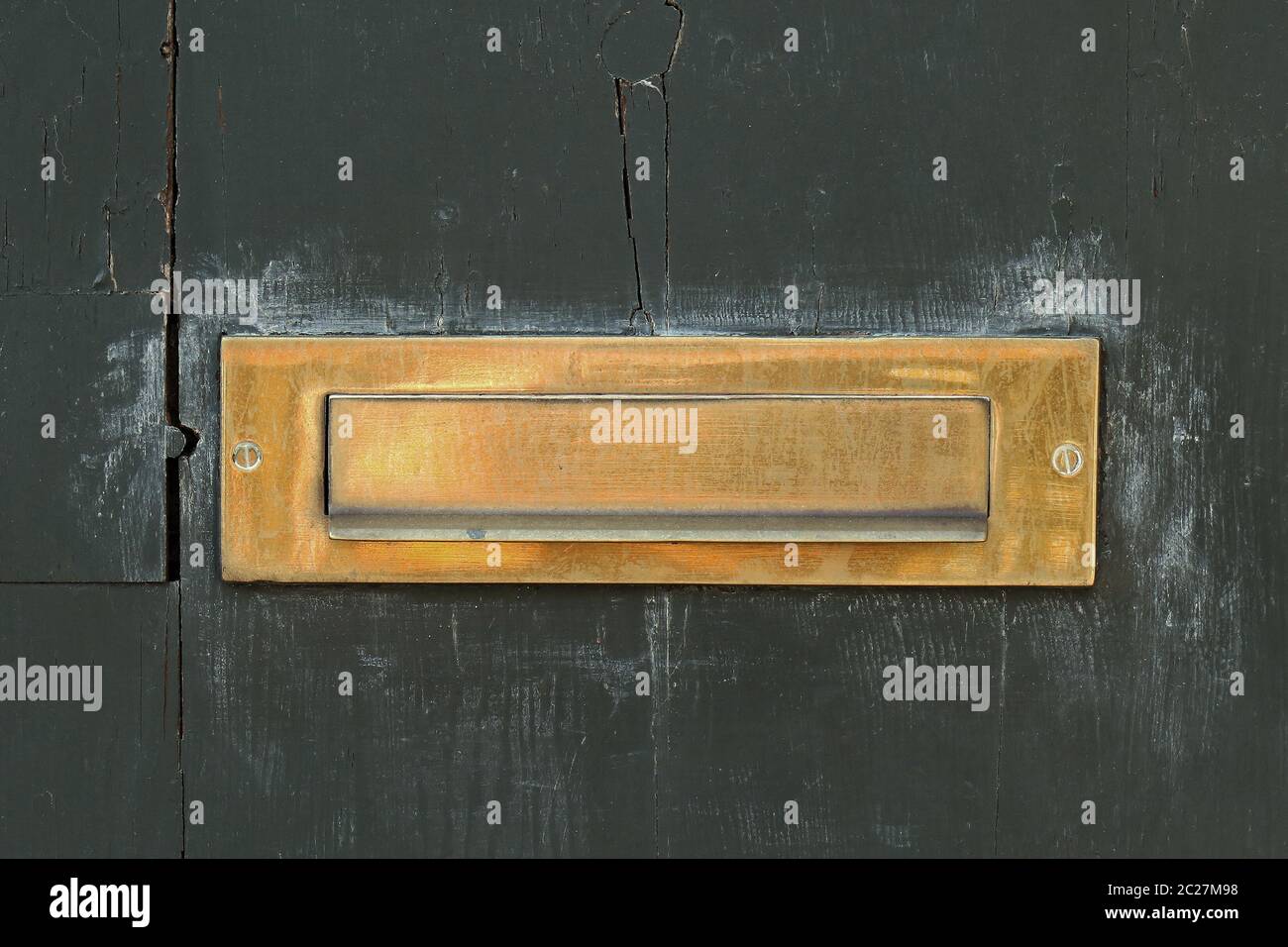 Old golden metal mail slot on wooden door exterior Stock Photo - Alamy