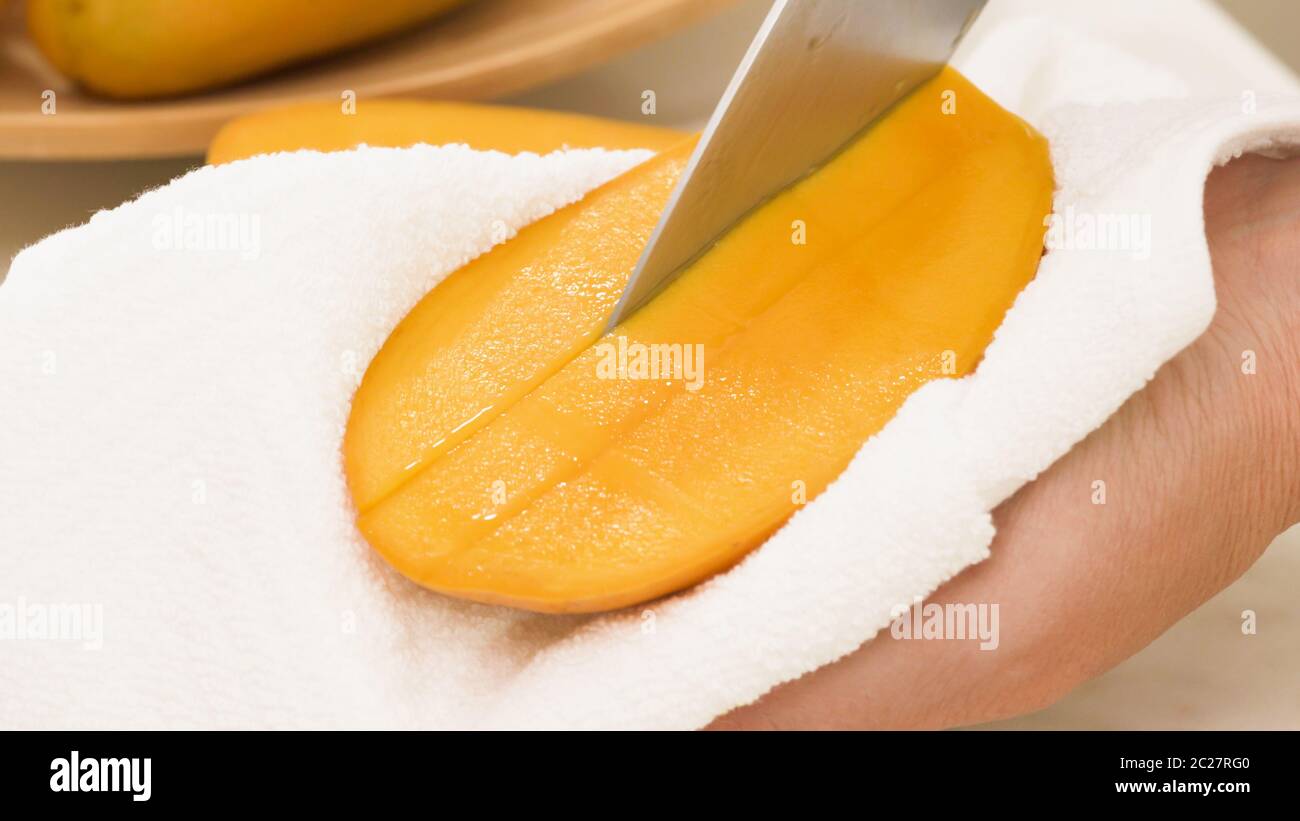 Fresh ripe organic yellow mangoes close up. Woman cutting mango on ...