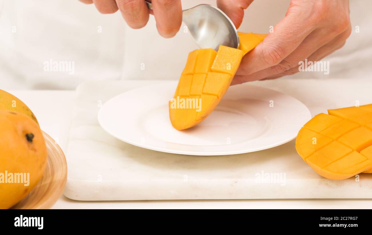 Fresh ripe organic yellow mangoes close up. Woman cutting mango on ...