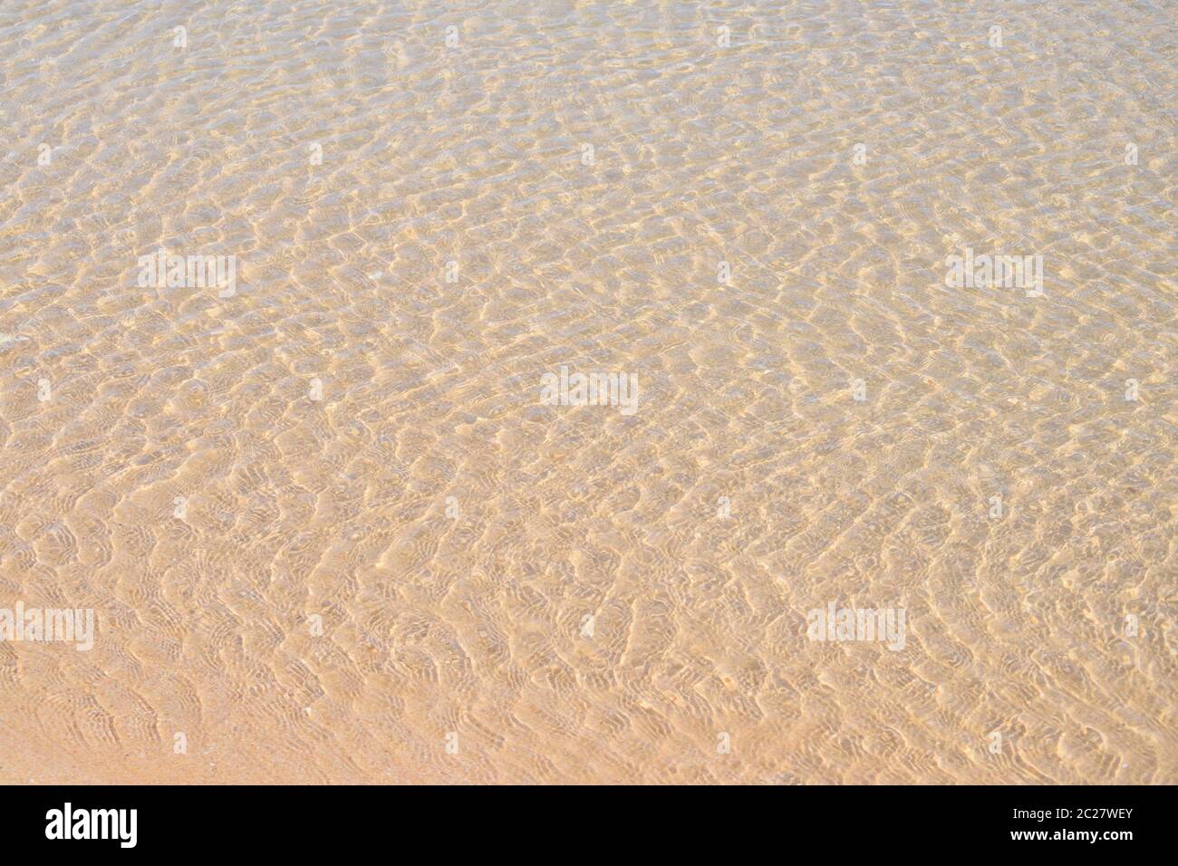 Little waves in the shallow water at the beach Stock Photo - Alamy