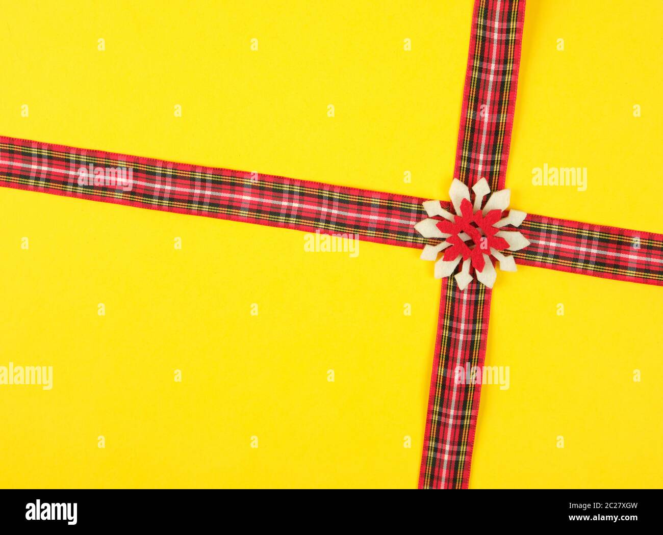 red decorative ribbon in a box cross on a cross on a yellow background ...