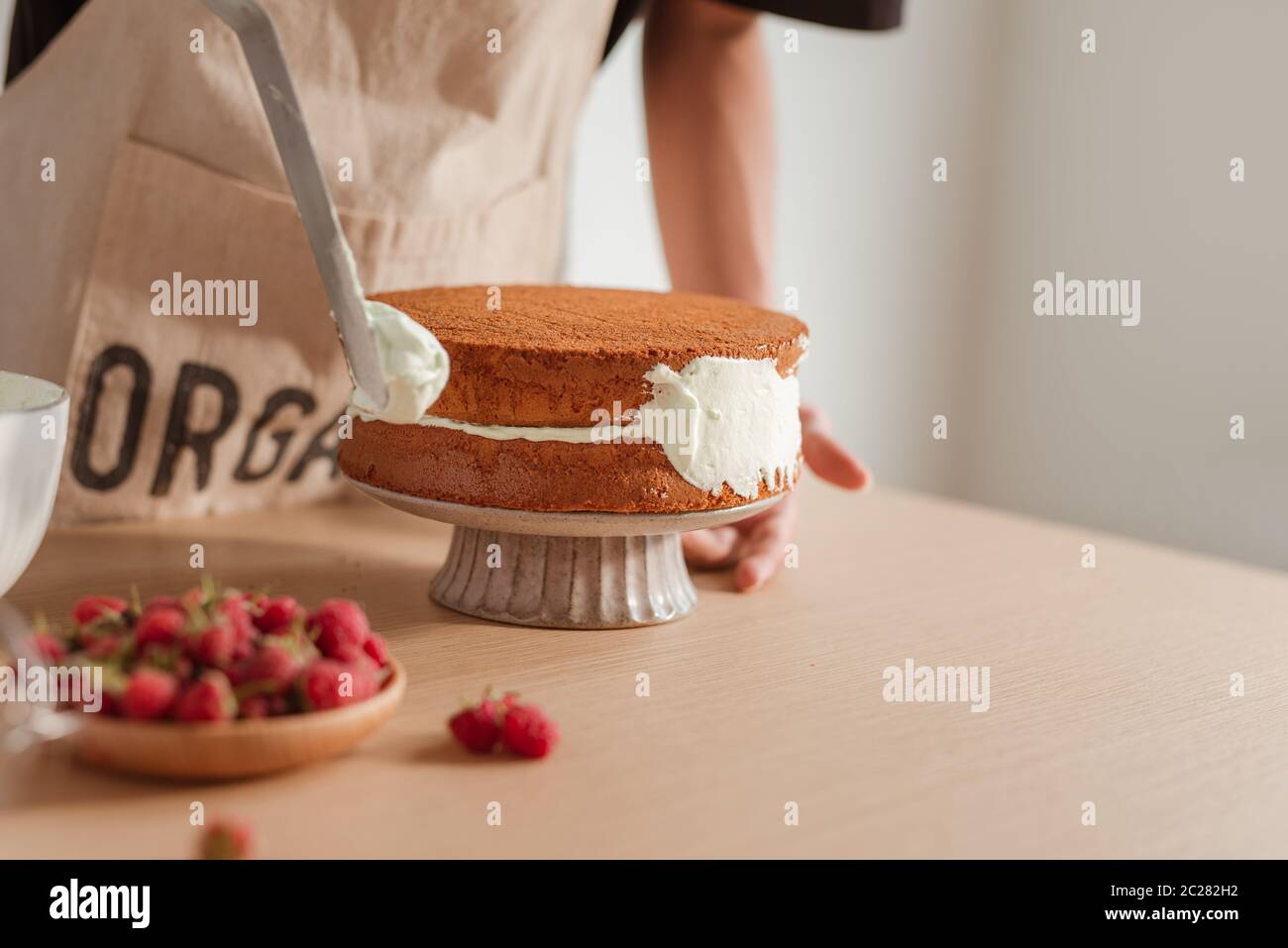 Pastry chef puts the cream on the Cakes. Process cooking sponge cake ...