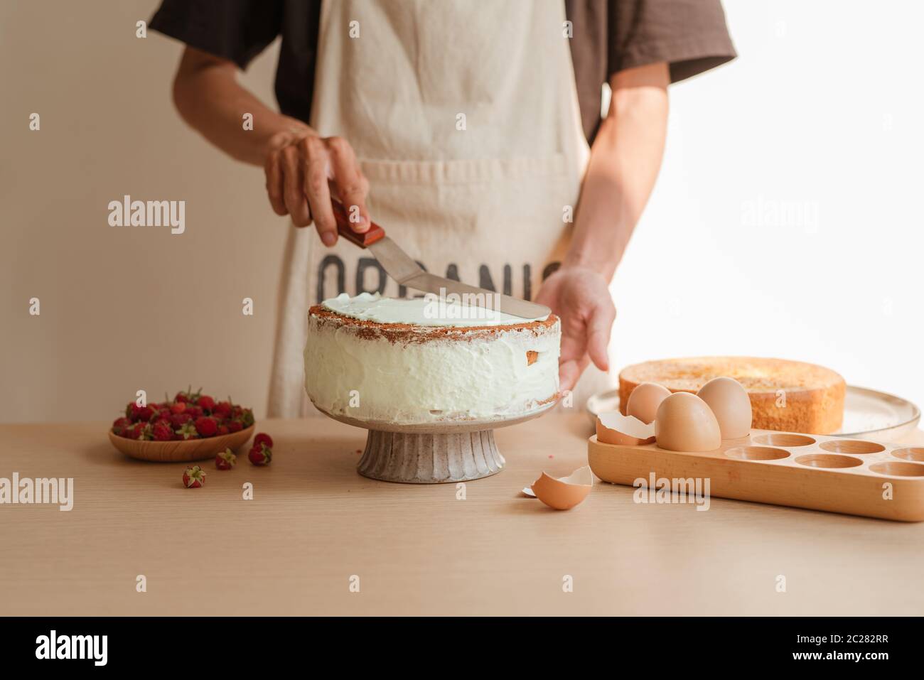 Putting the cream on top of sponge cake. Making sponge cake series ...
