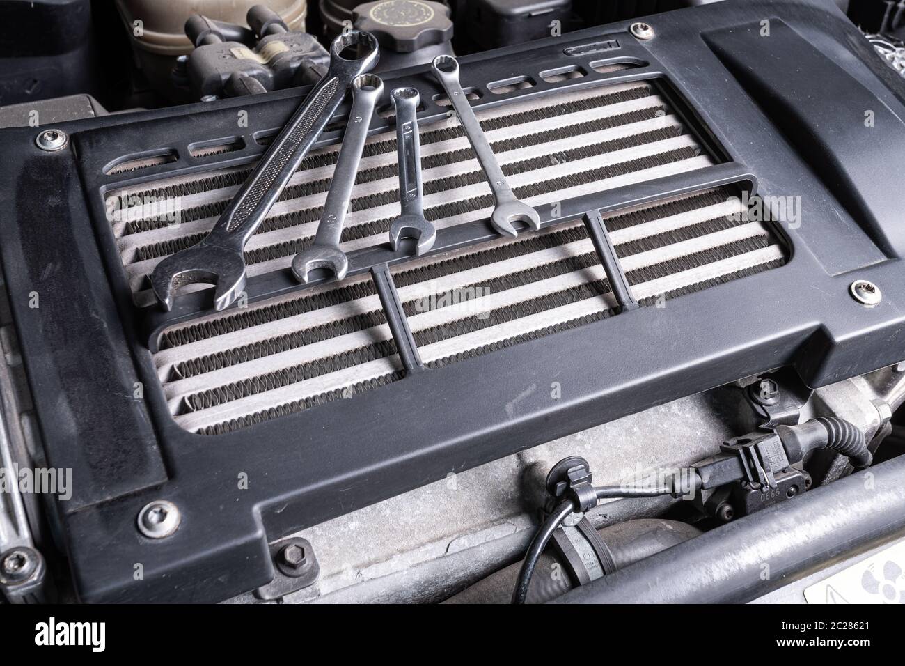 A set of metal spanners of different sizes lies under the hood of the ...