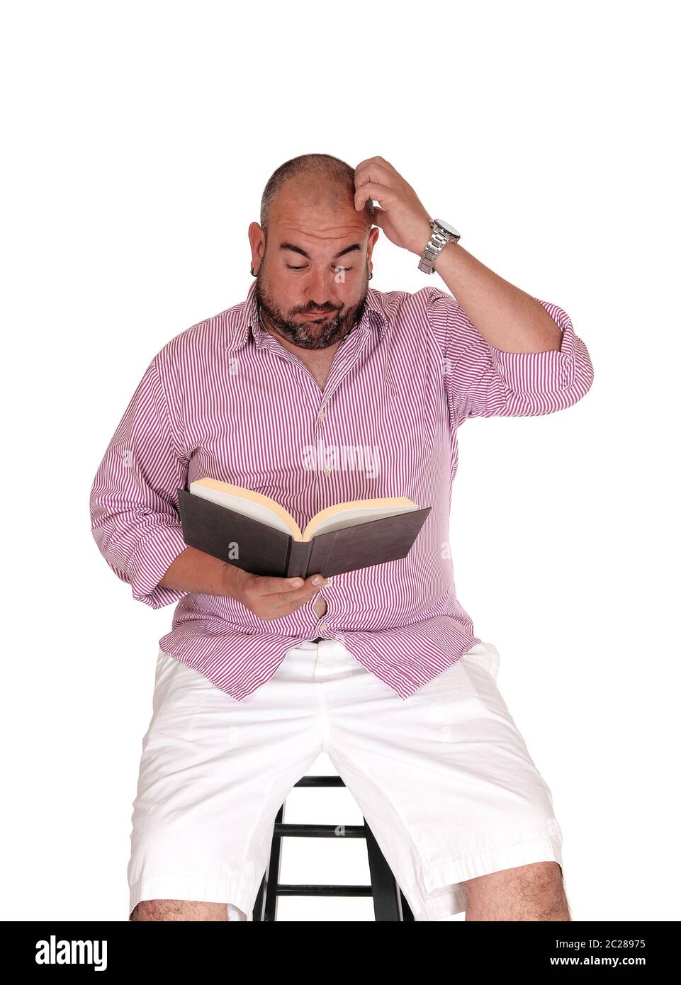 A millde age Hispanic man sitting on a chair, reading his book and ...