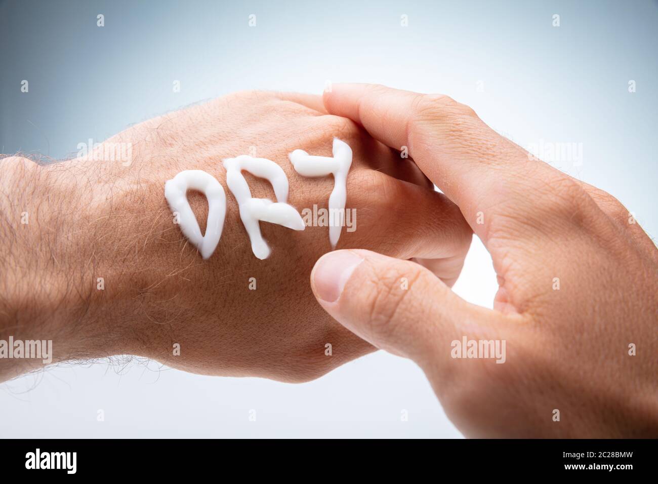 Close-up Of Dry Text Made With Lotion On Human Hand On White Background ...
