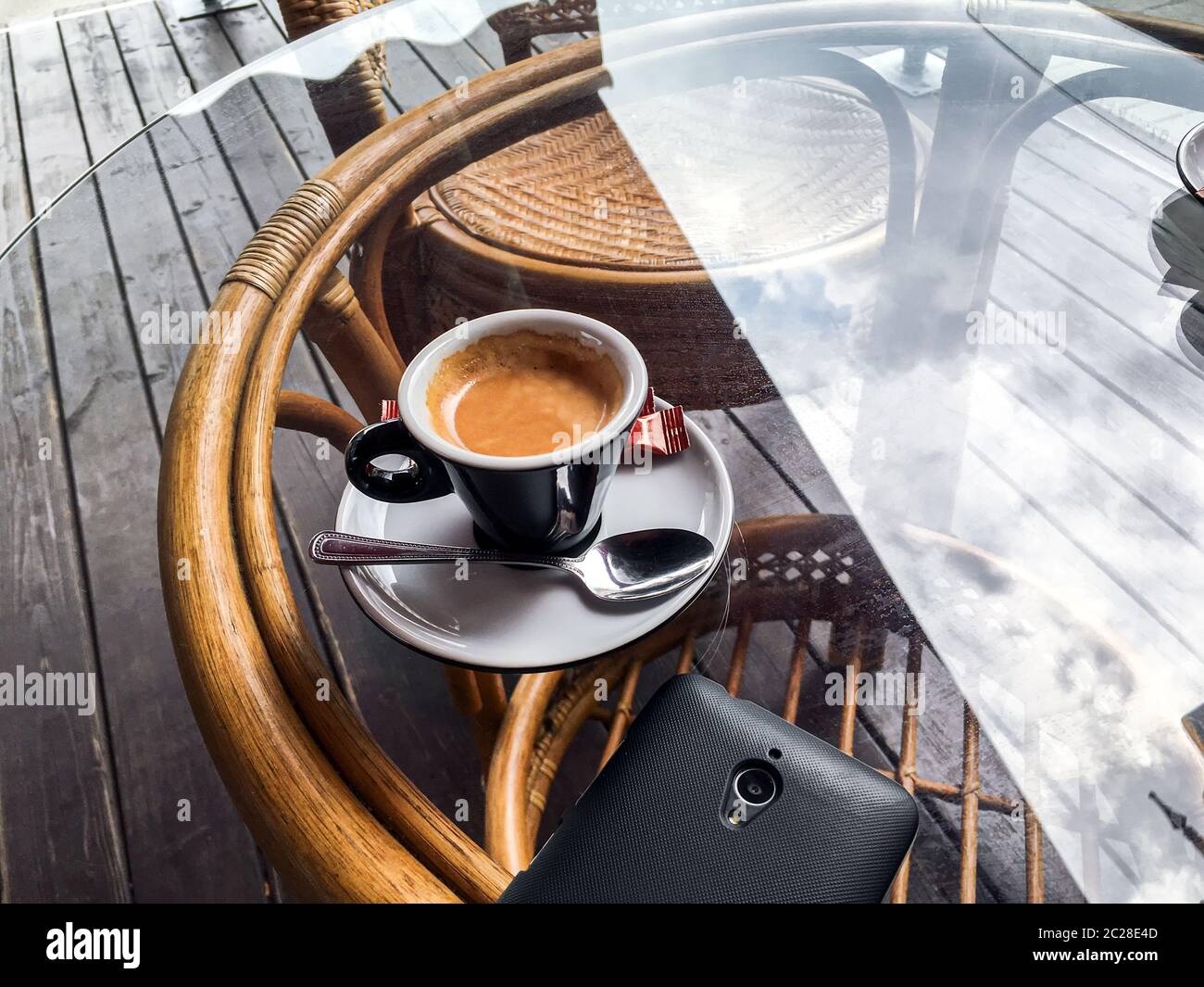 coffee cup on a glass table with sky reflections. coffee terrace with ...