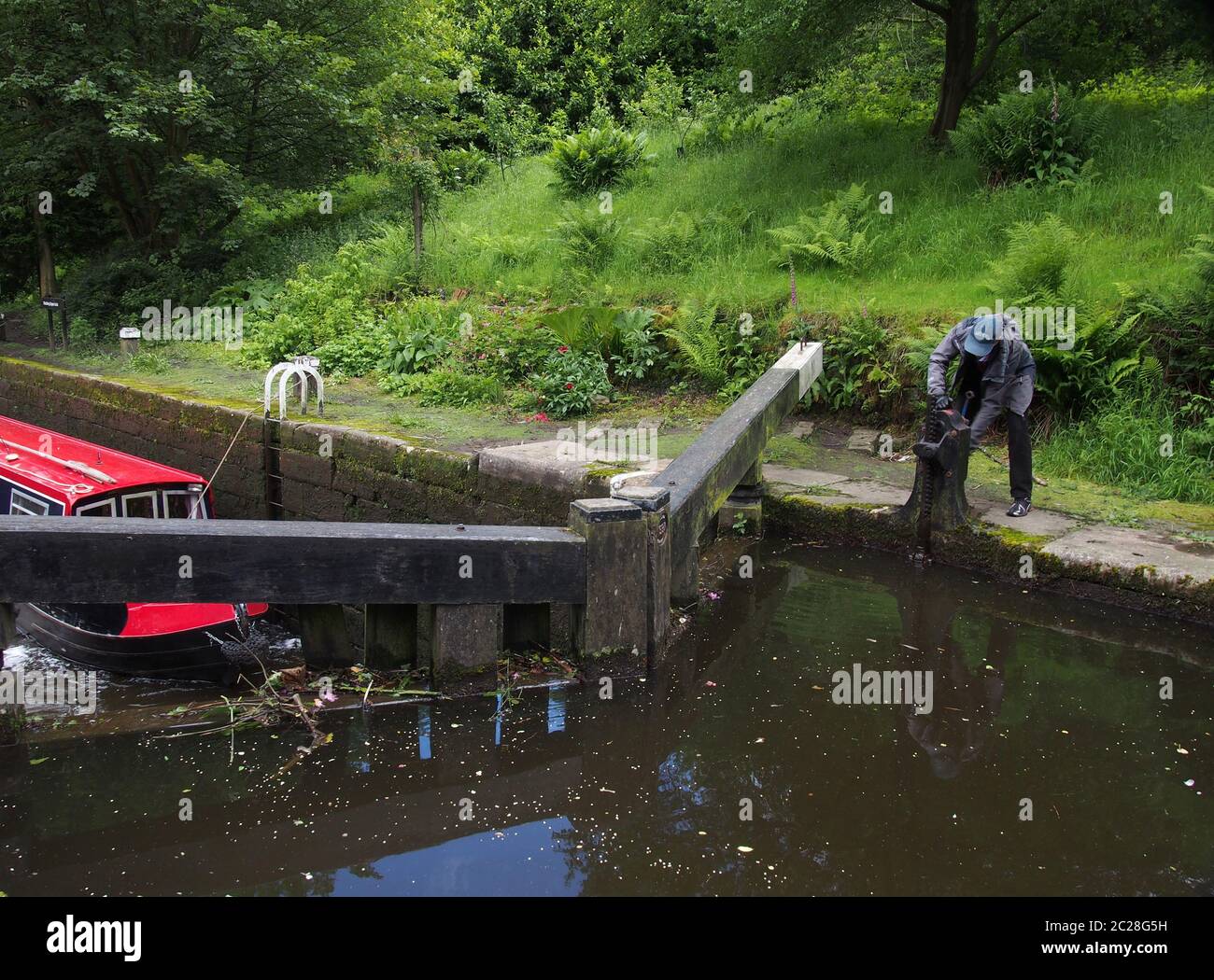 a woman opening a lock gate on the rochdale canal in hebden bridge west ...