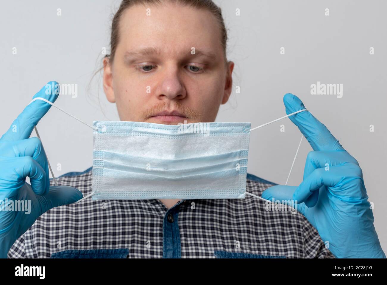 Guy puts on respiratory mask. Attractive man puts on face mask and ...