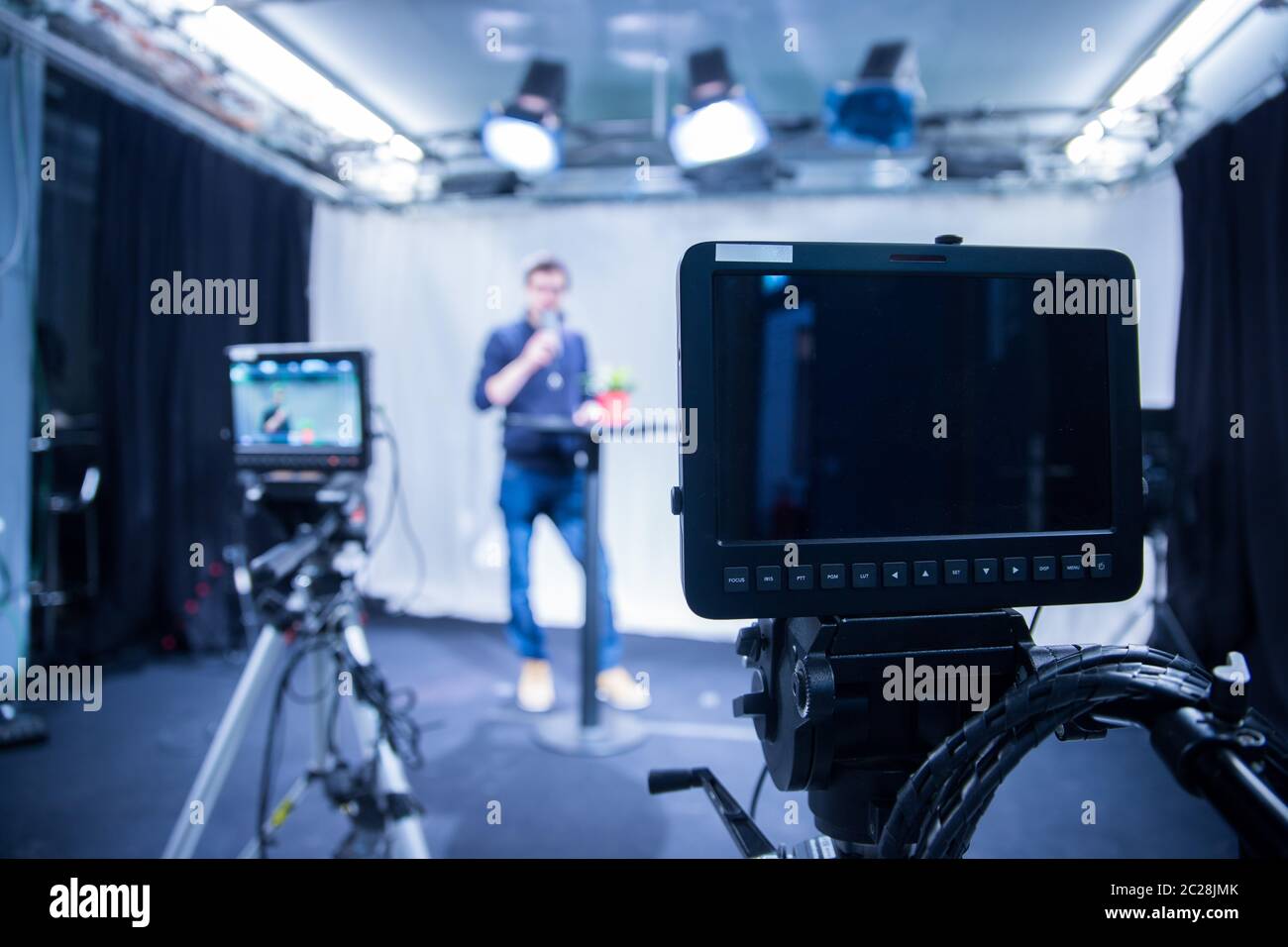 Journalist in a television studio is talking into a microphone, blurry ...