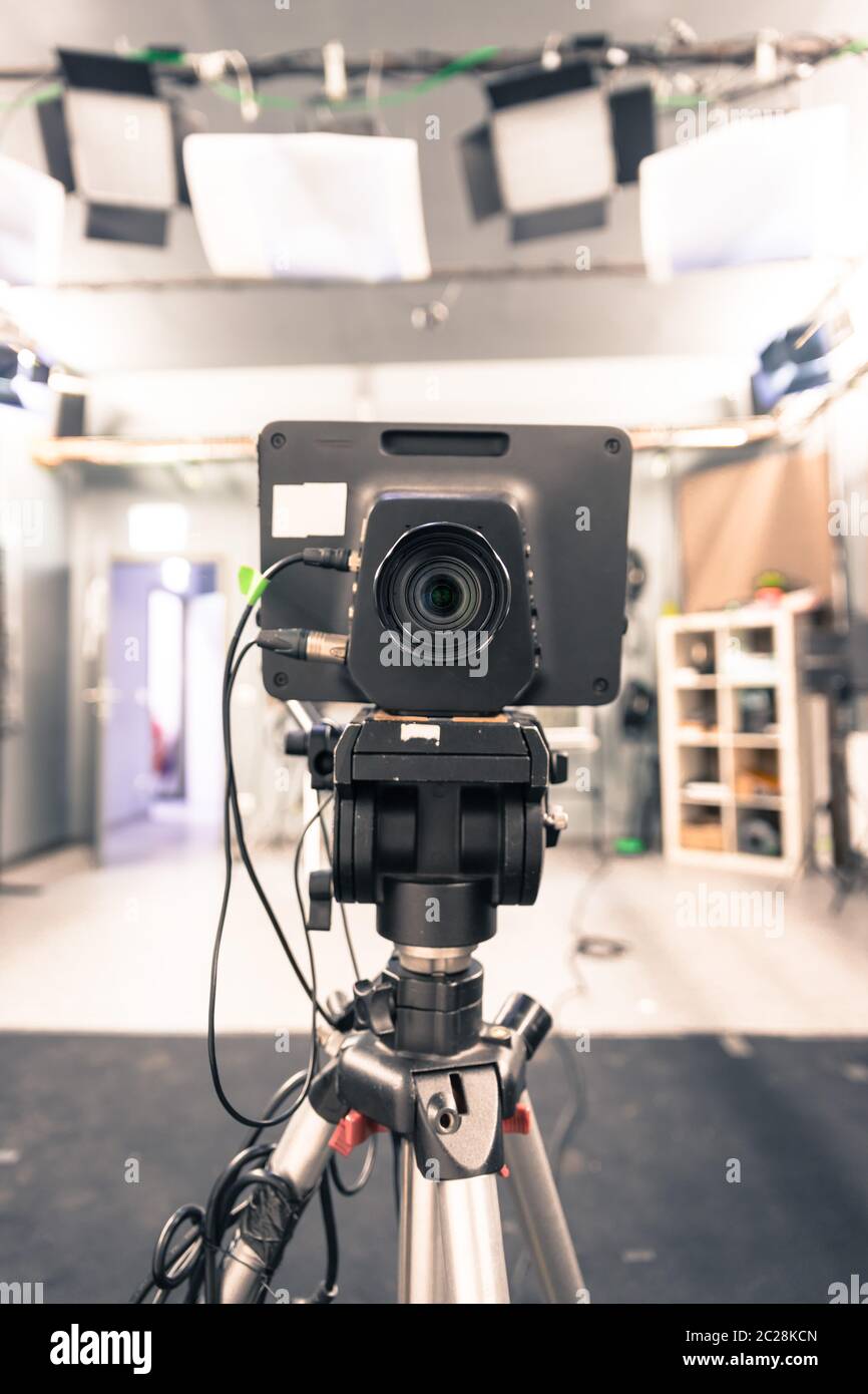Film camera in broadcasting studio, spotlights and other equipment ...
